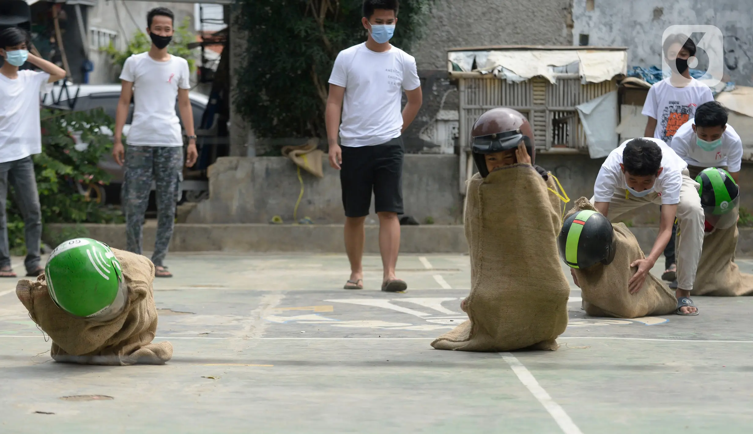 FOTO: Lomba Unik Balap Karung Memakai Helm - Foto Liputan6.com