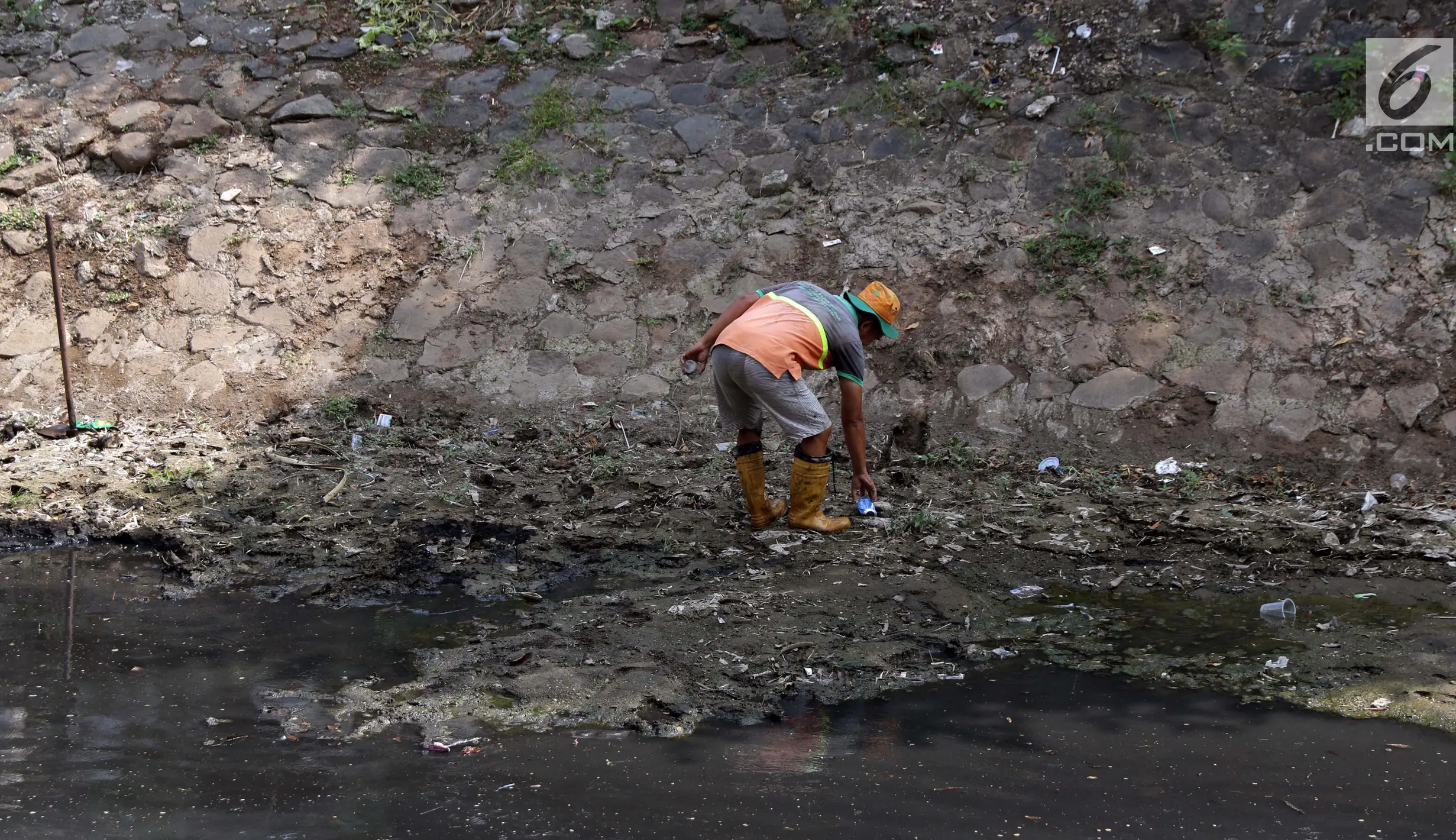 FOTO: Gunakan Cara Manual, Pekerja UPK Badan Air Bersihkan Kali Cideng - Foto Liputan6.com