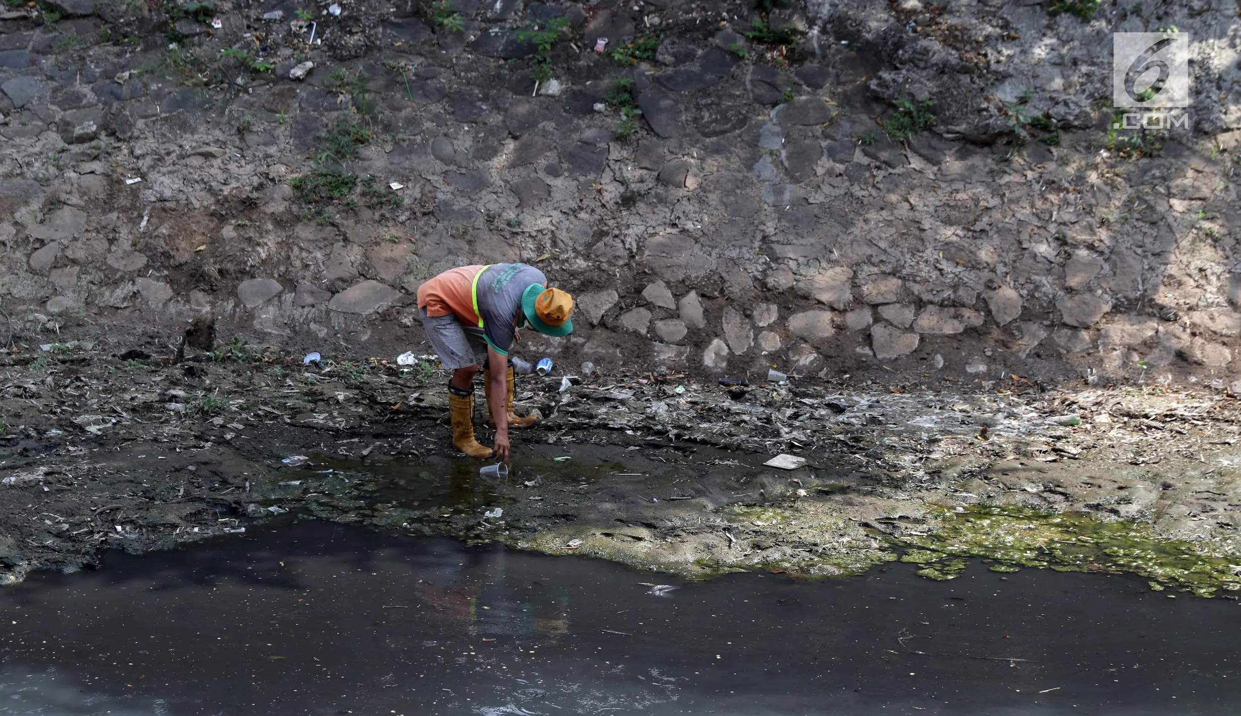 FOTO: Gunakan Cara Manual, Pekerja UPK Badan Air Bersihkan Kali Cideng - Foto Liputan6.com