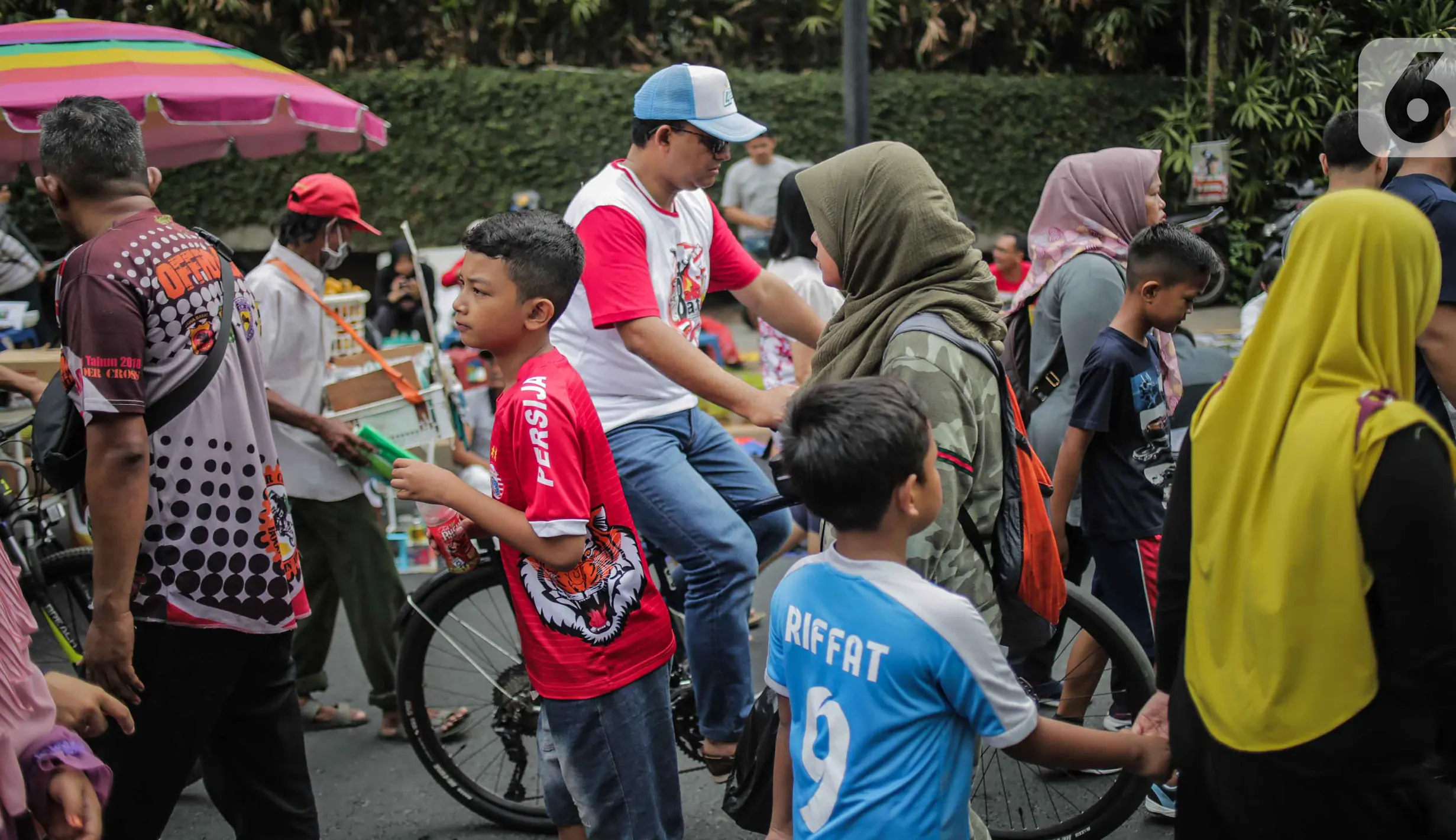 FOTO: Anies Baswedan Bersepeda di Tengah Kerumunan PKL saat CFD - Foto Liputan6.com