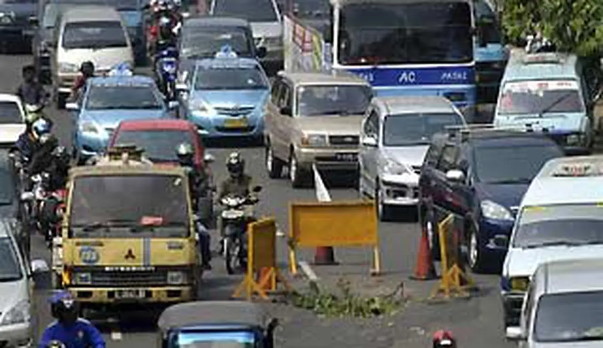 Sejumlah kendaraan melintas di samping jalan yang berlubang di Jalan ...