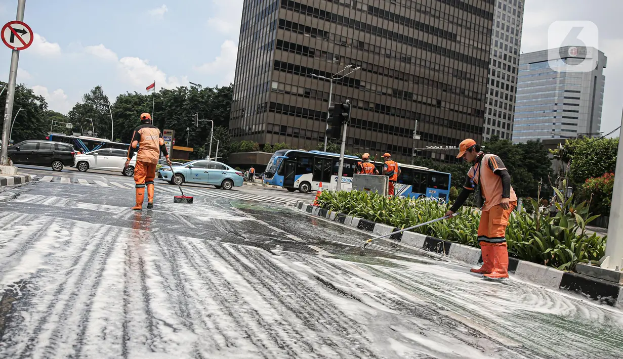 Membahayakan Pengendara Motor, Petugas Bersihkan Tumpahan Oli di Kawasan Sarinah - Foto Liputan6.com