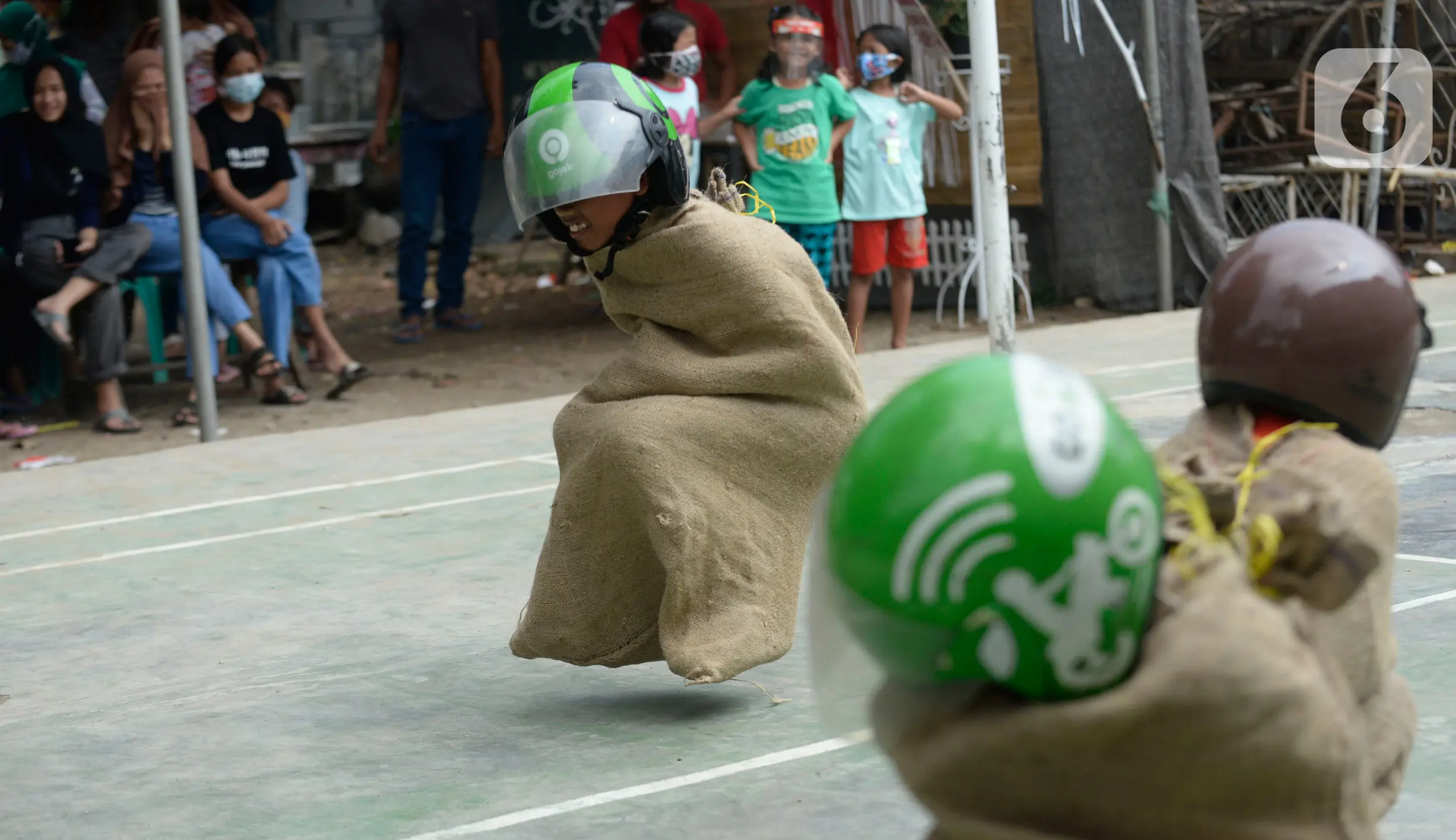 FOTO: Lomba Unik Balap Karung Memakai Helm - Foto Liputan6.com