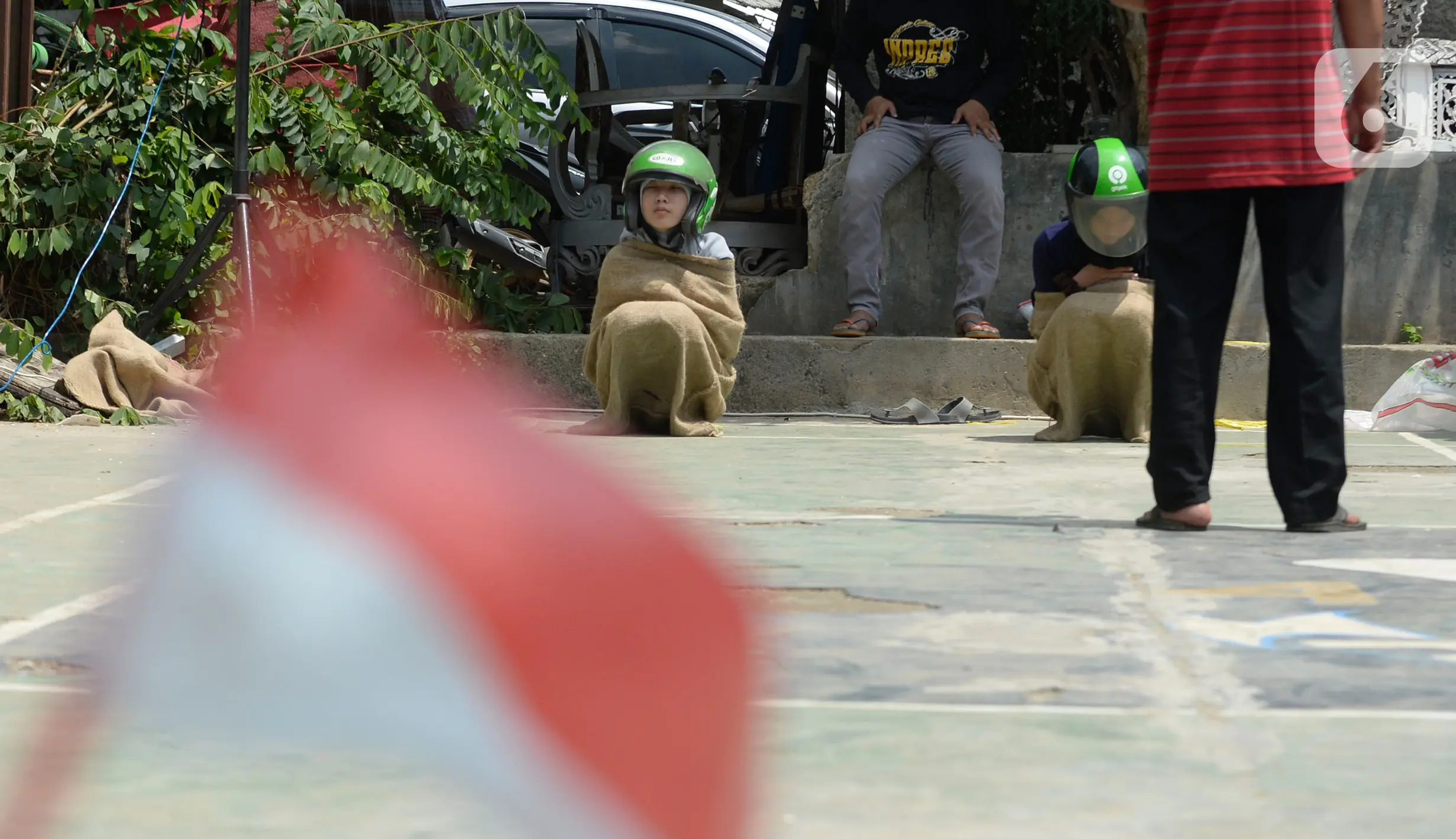FOTO: Lomba Unik Balap Karung Memakai Helm - Foto Liputan6.com
