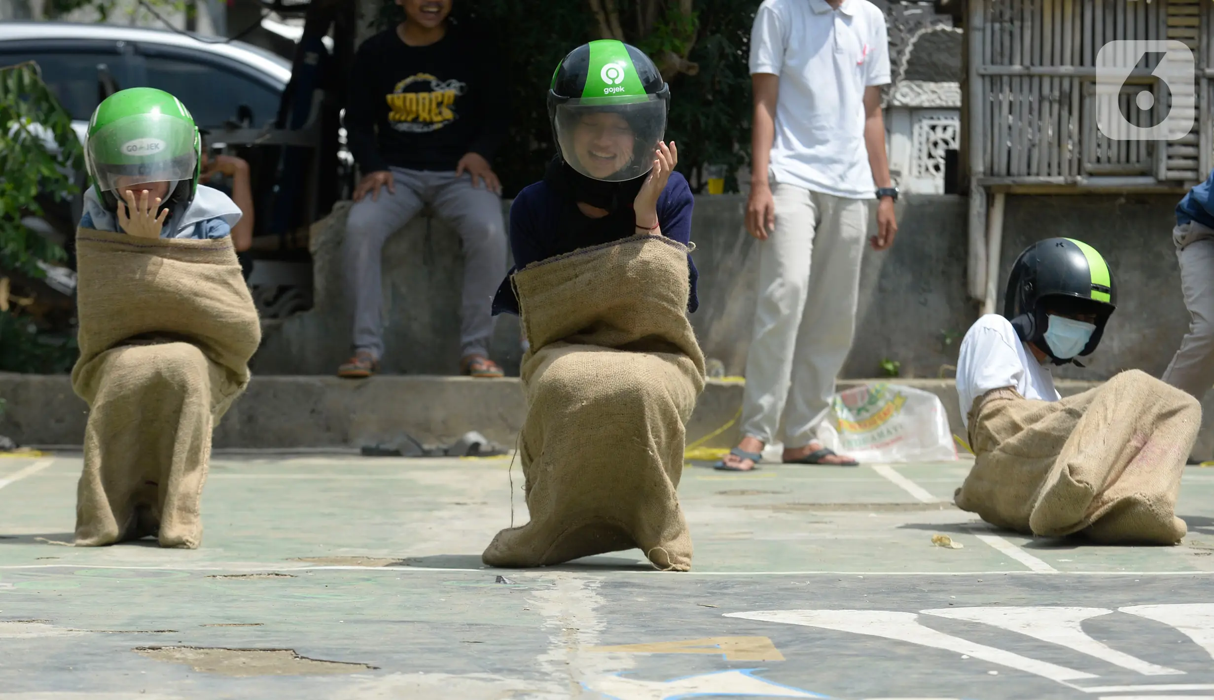 FOTO: Lomba Unik Balap Karung Memakai Helm - Foto Liputan6.com
