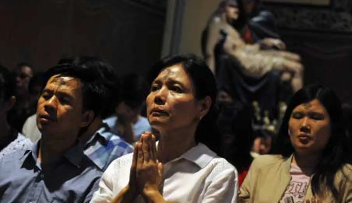 Jemaat berdoa usai pemberian tanda salib dari abu di dahinya saat misa ...