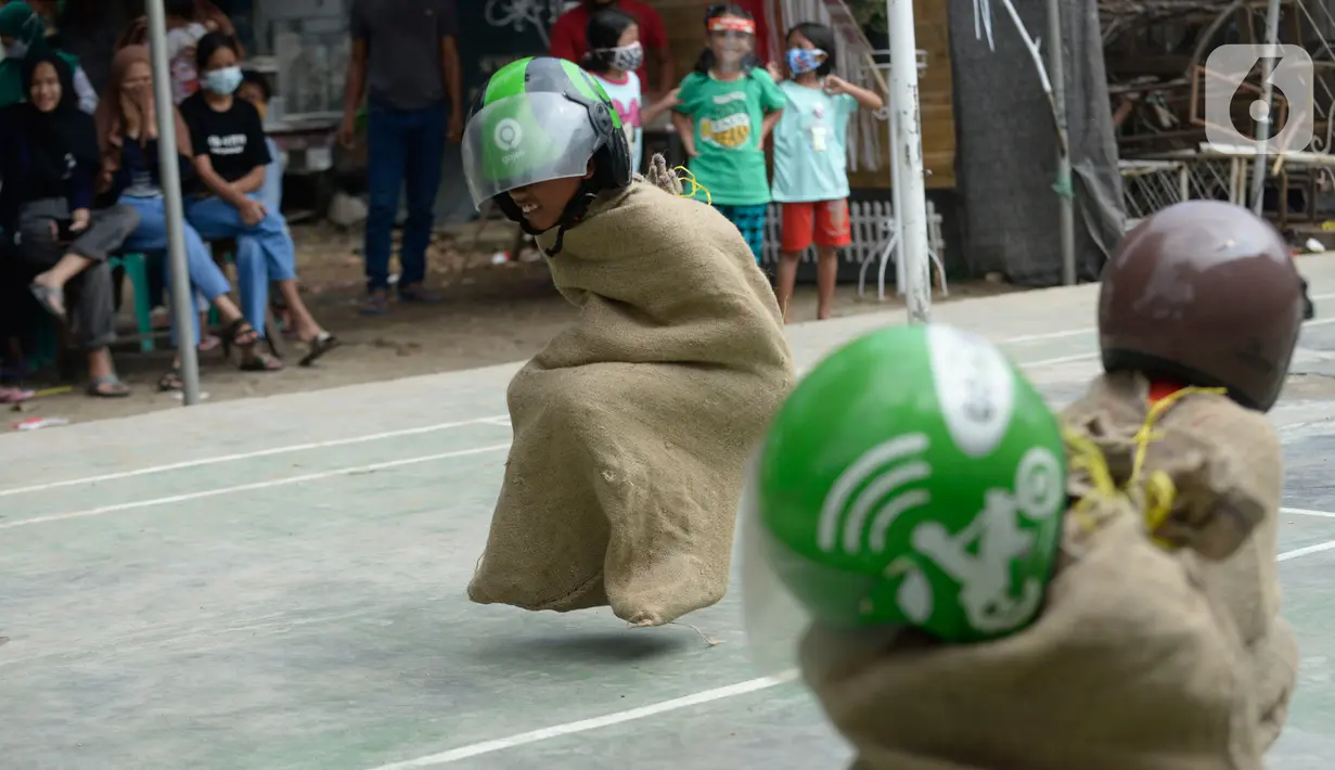 FOTO: Lomba Unik Balap Karung Memakai Helm - Foto Liputan6.com