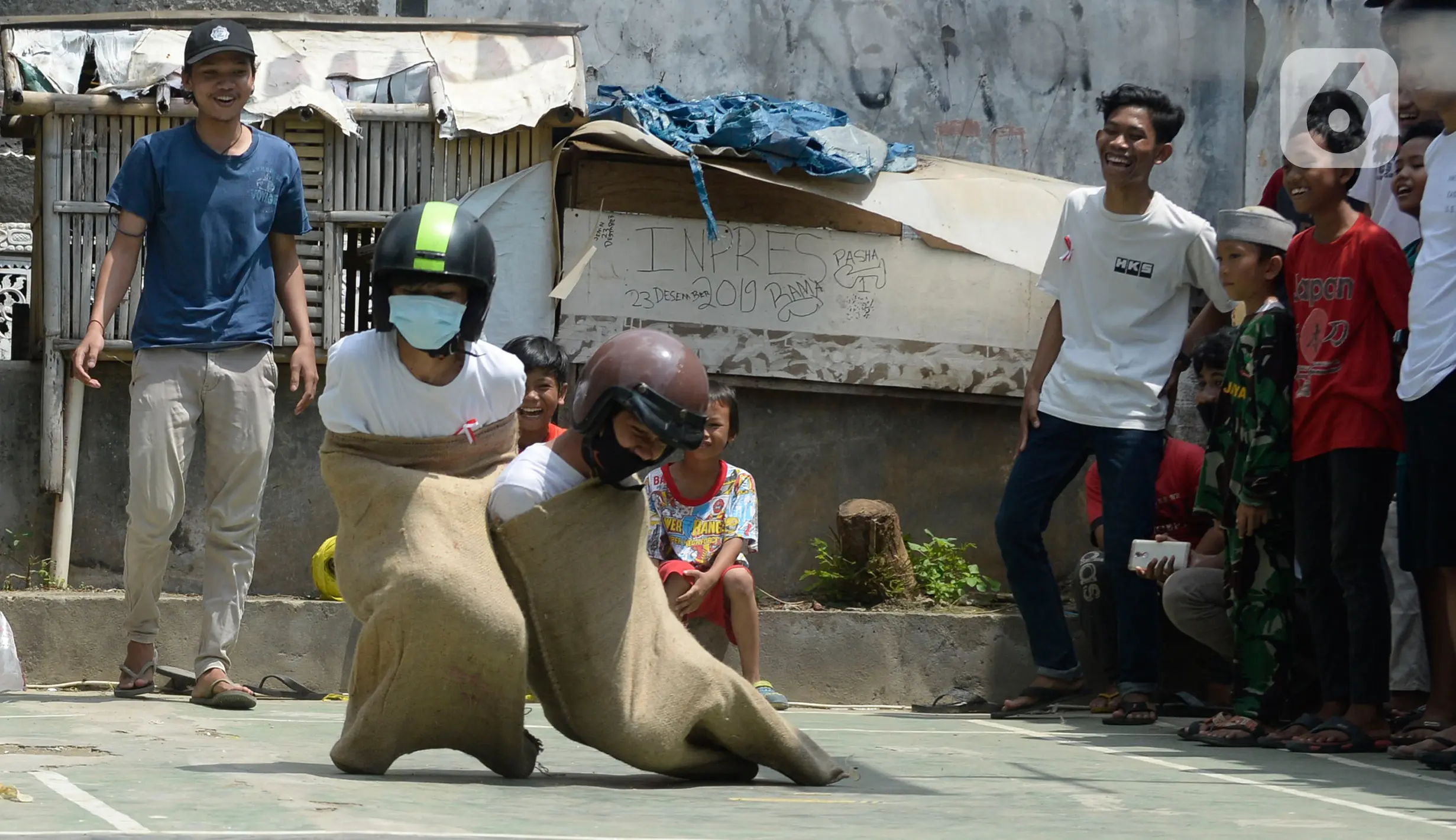 FOTO: Lomba Unik Balap Karung Memakai Helm - Foto Liputan6.com