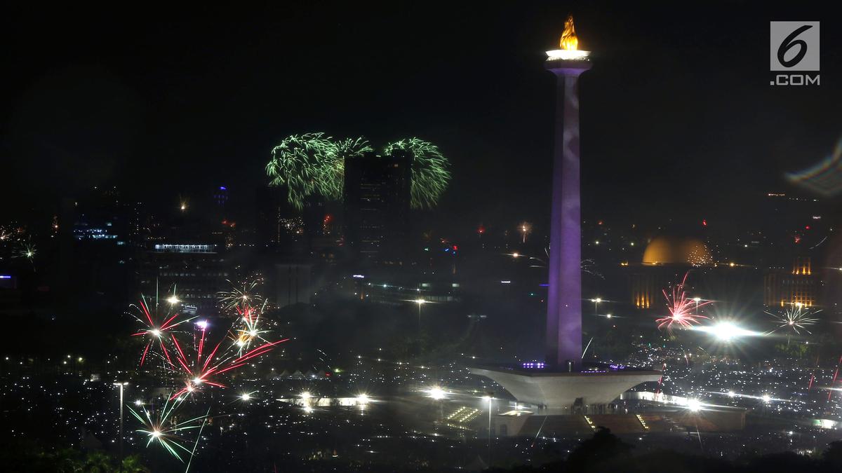 FOTO: Diguyur Hujan, Kembang Api Sambut Pergantian Tahun di Monas - Foto Liputan6.com