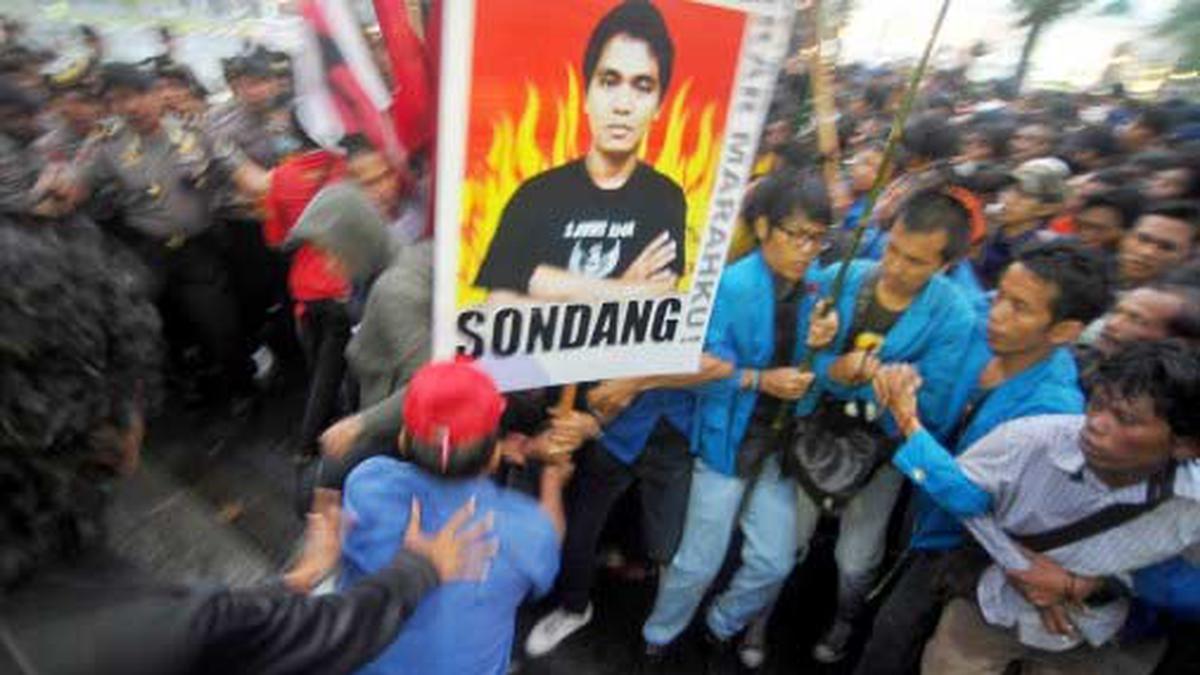 Gabungan mahasiswa didorong mundur oleh aparat polisi saat aksi mengenang Sondang Hutagalung di ...