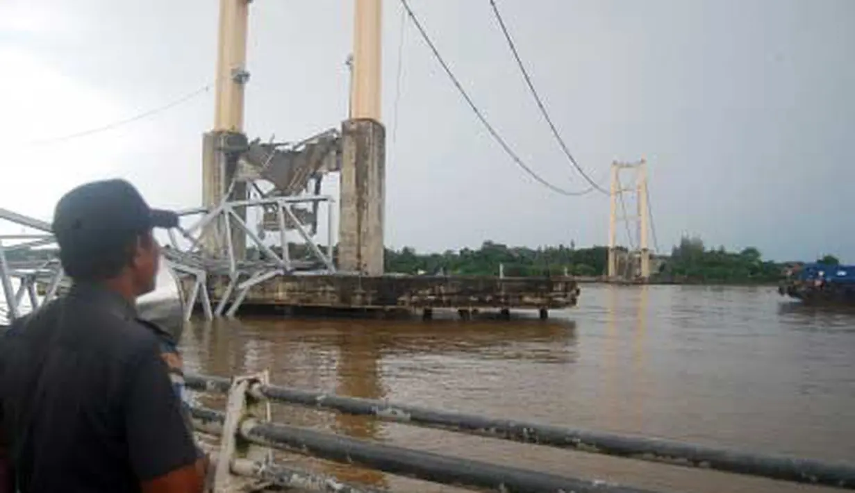 Seorang warga menyaksikan kondisi kerangka Jembatan Kartanegara yang ambruk ke Sungai Mahakam ...